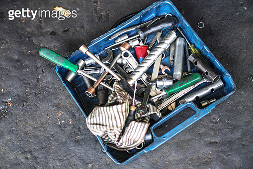 Different dirty tools in the box. The tools are old in the workshop ...