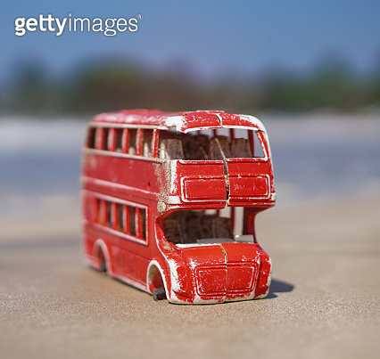 Red toy bus in nature pollutes the earth's ecosystem. English bus ...