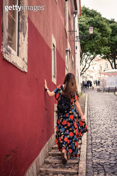 Woman exploring the streets of the Alfama District in Lisbon, Portugal ...