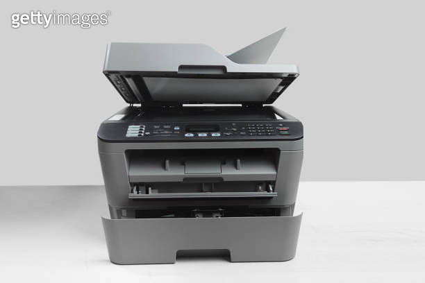 A multi function printer, copier, scanner on office table. gray wall ...