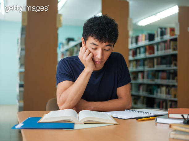 Latin student doing intense reading 이미지 (1135517398) - 게티이미지뱅크