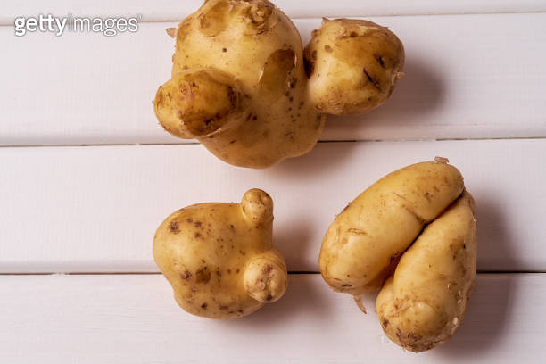 Trendy ugly curved potatoes on white wooden background. 이미지 (1163306458 ...