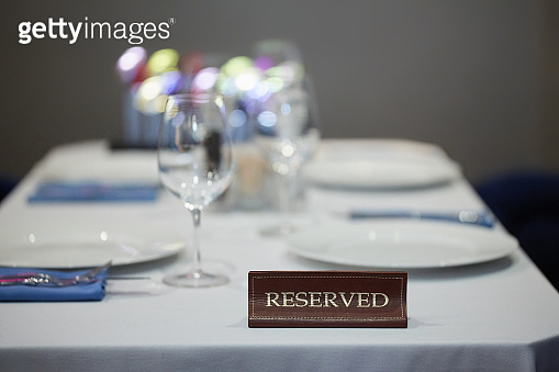 Restaurant reserved table sign with places setting and wine glasses ...