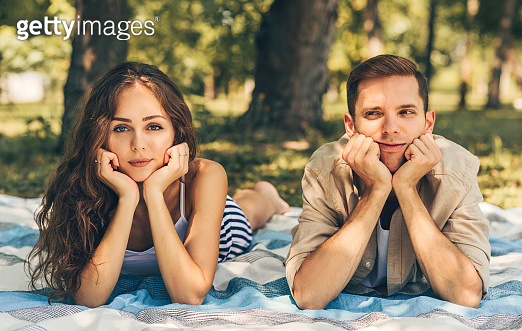 Image of upset couple feeling sad to each other lying outdoors at the ...