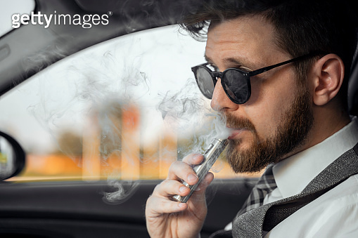 Elegant Man smoking e cigarette (1164970035) - 게티이미지뱅크