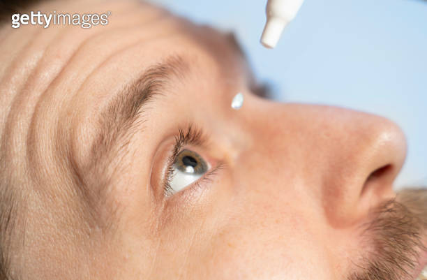 Closeup man applying eye drops, drop in mid air 이미지 (1167673586) - 게티이미지뱅크
