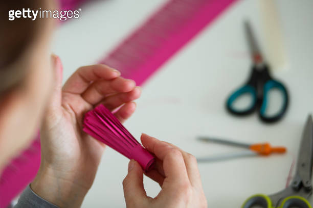 Creating shapes while bending paper to make paper flowers (1173191026 ...