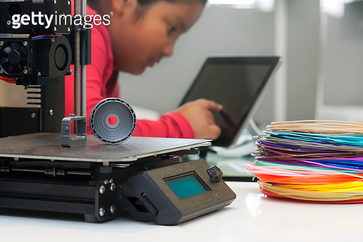 A 3d printer with two 3d models that have finished printing on the ...