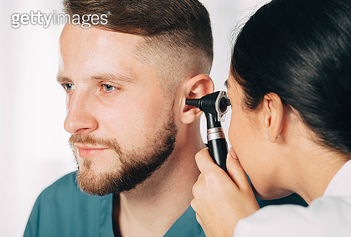 man getting medical ear exam at clinic. Audiologist Examining male ...