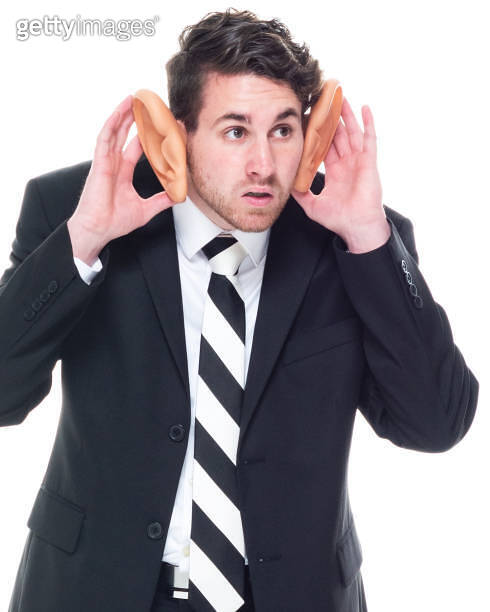 Handsome businessman wearing a black suit - has big ears for listening ...