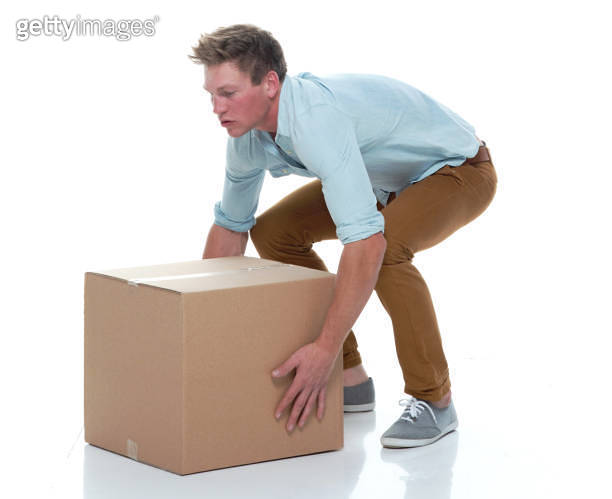Good looking man lifting a box 이미지 (1143515858) - 게티이미지뱅크