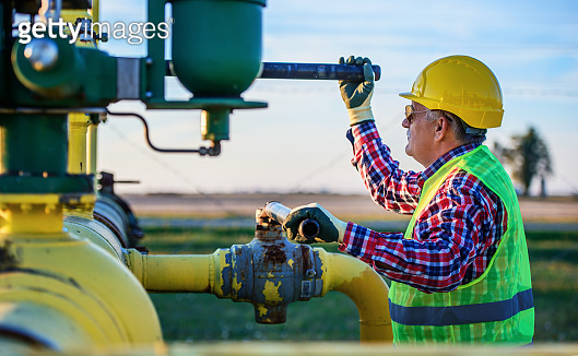 Worker checking valves on the fuel supply systems. Concept of industry ...