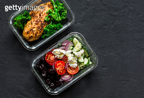Two healthy balanced lunch boxes with greek salad, baked chicken breast ...