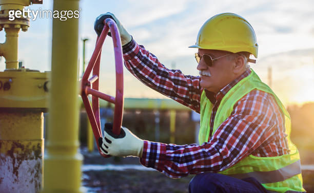 Worker checking valves on the fuel supply systems. Concept of industry ...