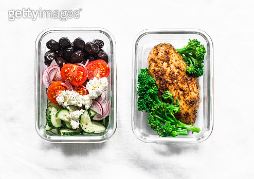 Two healthy balanced lunch boxes with greek salad, baked chicken breast ...
