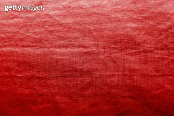 Dirty crumpled red synthetic fabric texture with a well-traced light ...