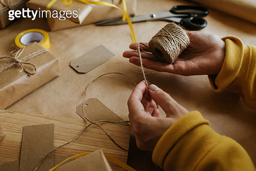 Woman packaging presents. Kraft wrapping paper and natural twine ...