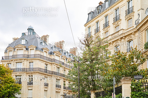Ancient luxury buildings facade with trees and railings with golden ...