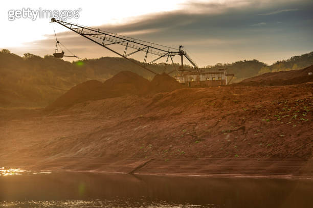 Red clay quarry with old heavy excavator for digging during bright ...