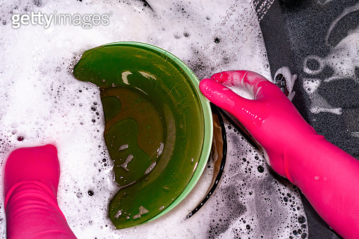 The process of washing plates in the sink, hands and plates closeup ...