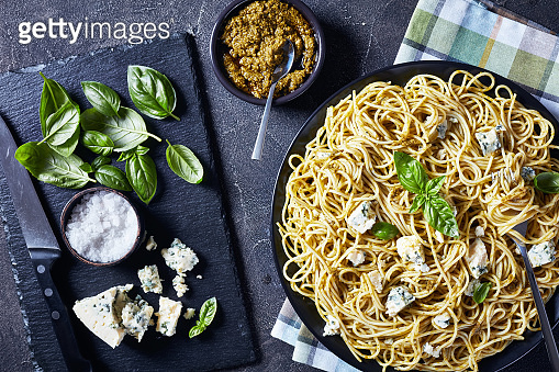 Spaghetti with genovese basil pesto and blue cheese on a black plate ...