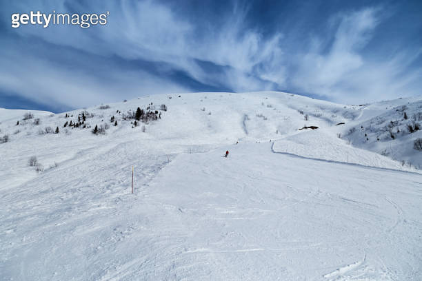 Winter mountain and blue sky with beautiful clouds. Hard shadows fall ...