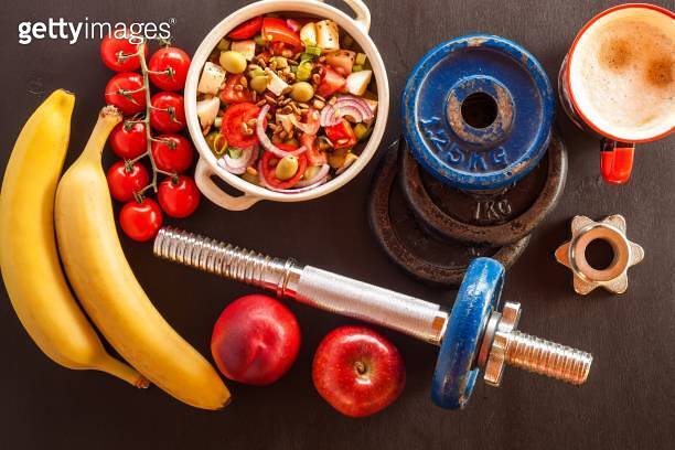 Vegetable salad and dumbbell. Weight reduction concept. Healthy food ...