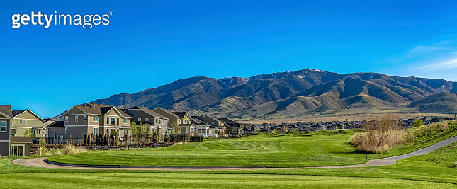 Paved pathway on a vast grassy terrain leading to the houses in the ...