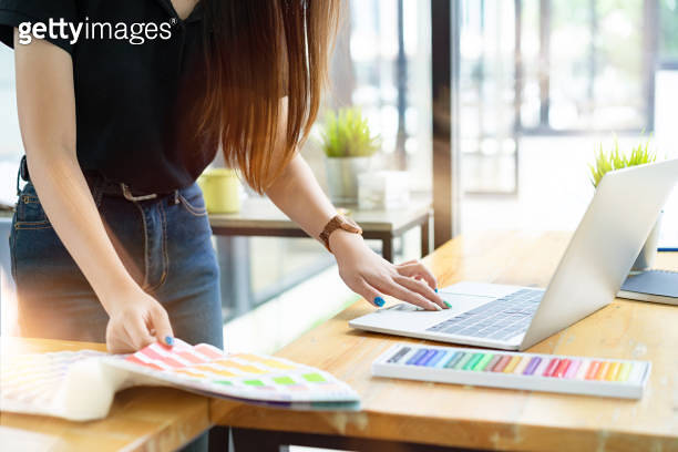 Attractive young freelance graphic designer choosing color from color ...