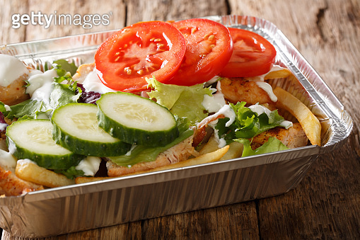 Delicious dinner Dutch kapsalon of french fries, chicken, fresh salad ...