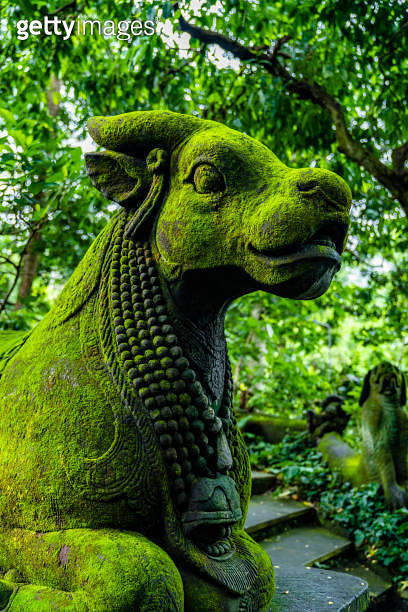 Monkey forest in Ubud. Moss covered stone Statue Of An Ancient Deity ...