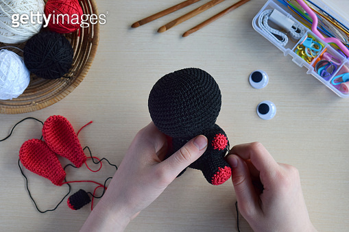 Making crochet voodoo rabbit. Toy for Halloween. On the table threads ...
