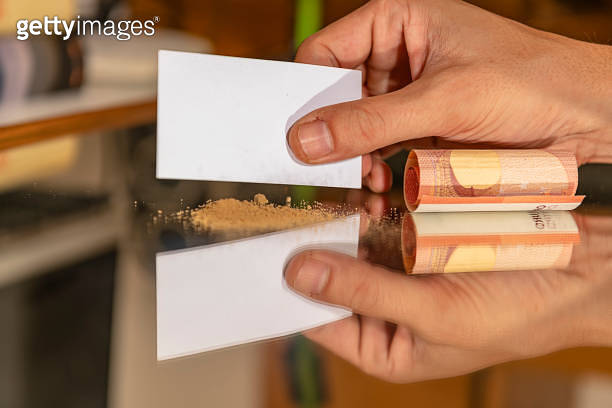 Preparing a Snorting Lines of Brown Powder (1193257789) - 게티이미지뱅크