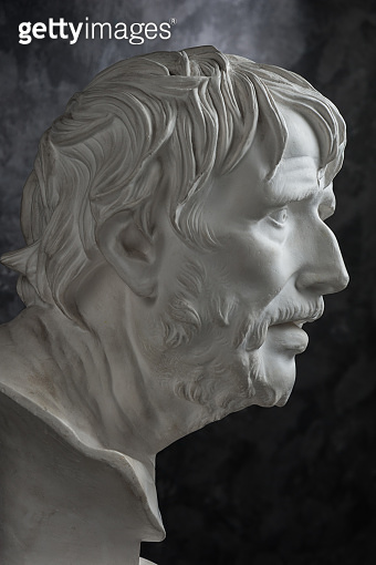 Gypsum copy of ancient statue Seneca head on dark textured background ...