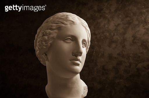 Gypsum copy of ancient statue Venus head on a dark textured background ...