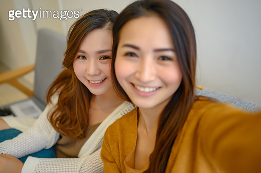 2 Asian Chinese Female Sister Taking Selfie In The Living Room On The