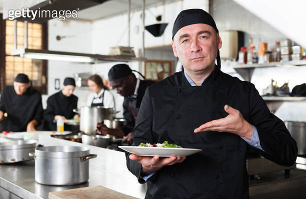 Positive male cook with cooked dish in restaurant kitchen 이미지 ...