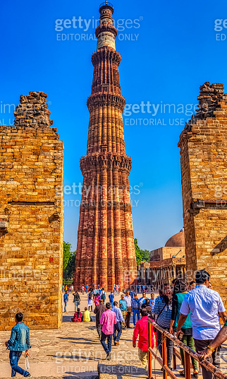 Qutb Minar tower seen through the ruined mosque at Qutub Minar complex ...