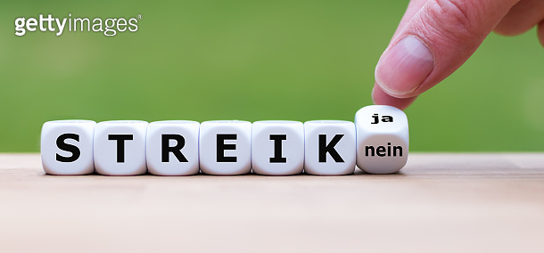 Hand is turning a dice and changes the word 'ja' to 'nein' (German for ...