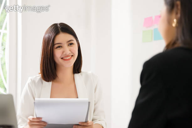 A young attractive asian woman is interviewing for a job. Her ...