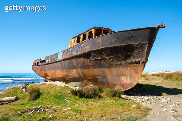 Abandoned rusty shell of the old shipwreck Magnet beached on Wairarapa ...