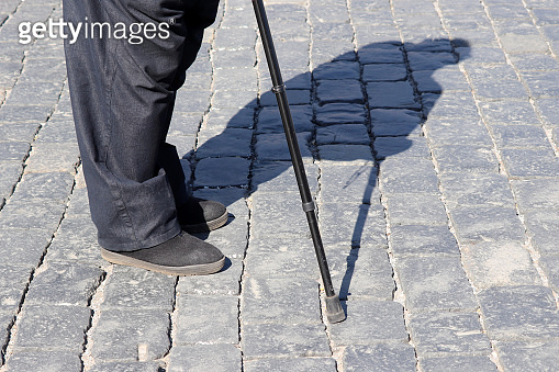 Old man standing on a street with walking cane, shadow on pavement 이미지 ...