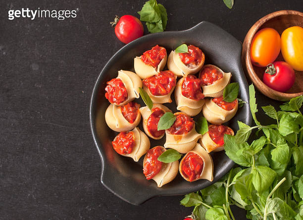 Stuffed large shells pasta with meat and tomatoes in sauce. Cancelloni ...
