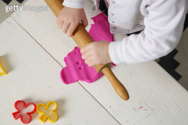 Toddler girl playing with modelling clay. Play dough allows kids to ...