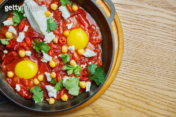 Close up view on shakshuka with hot chili pepper in tomato juice with ...