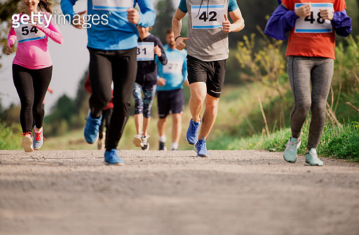 Midsection of large group of people running a race competition in ...