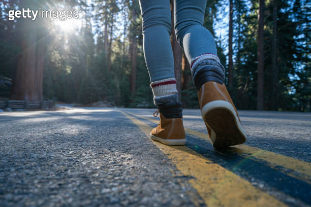Low angle view of woman walking on middle lane highway in USA 이미지 ...