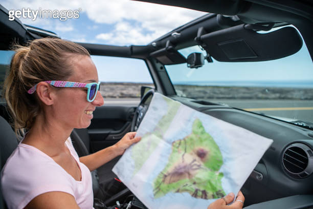 Young woman inside 4x4 car looking at road map for directions 이미지 ...