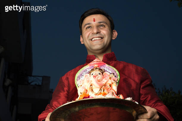 Man carrying statue of Hindu god Ganesh (1273486109) - 게티이미지뱅크