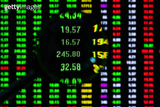 Close up of declining stock market data using a magnifying glass ...